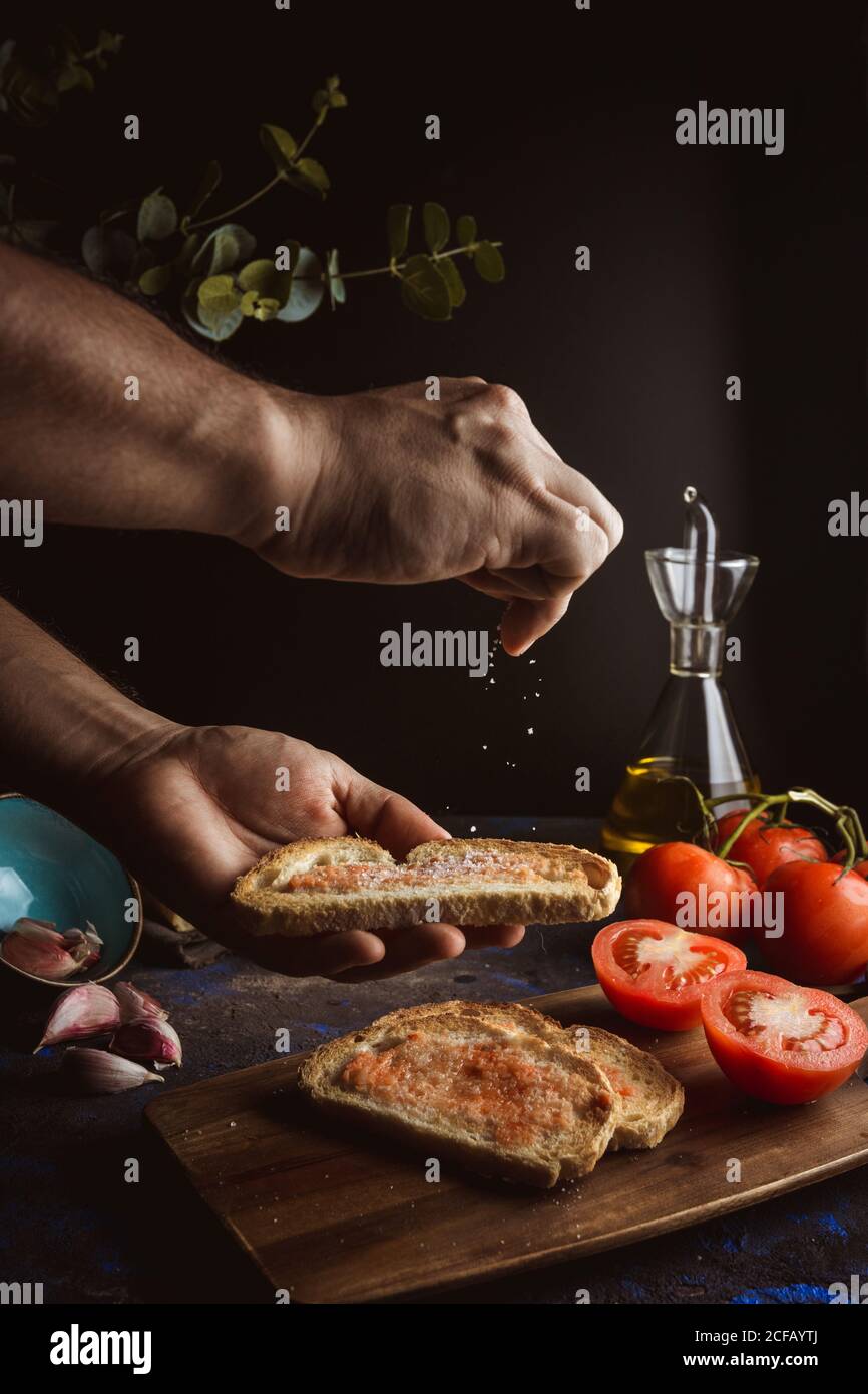Crop person pouring salt on toasts Stock Photo - Alamy