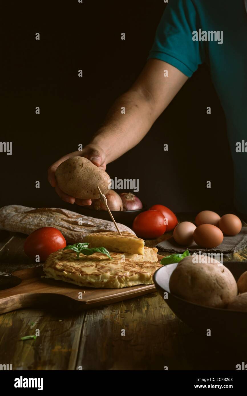 Crop man holding potato near pie Stock Photo - Alamy