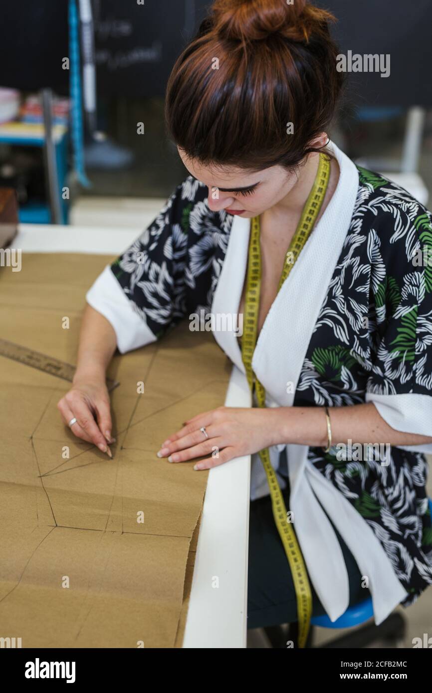 Teenage girl student practicing sewing on modern machine in cozy ...