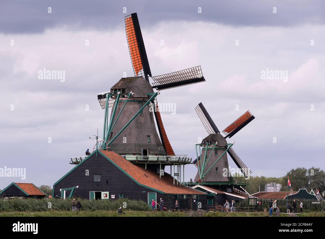 People walk past the Oilmill or Brightly Coloured Hen, a windmill at ...