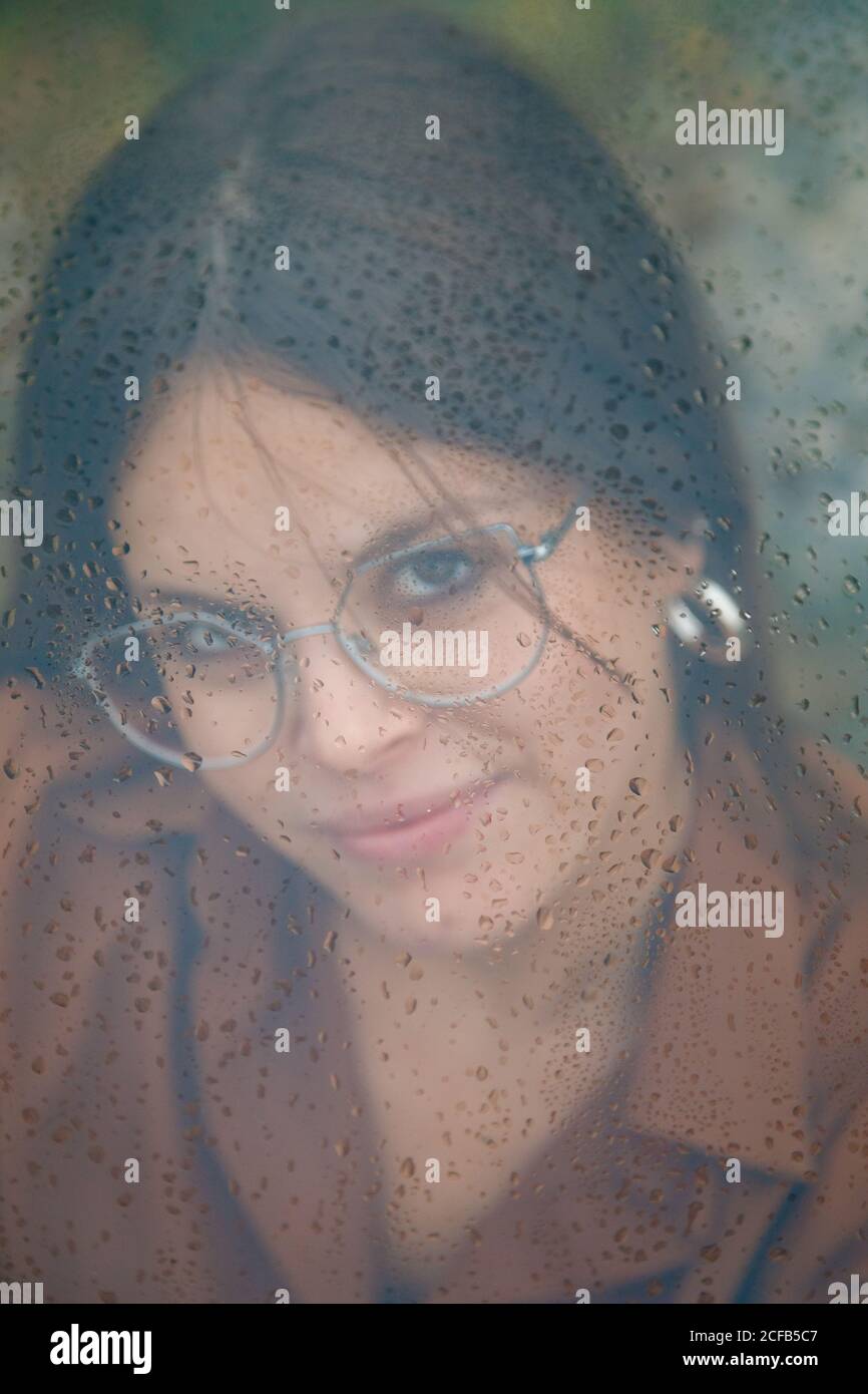 Woman looking out rainy window hi-res stock photography and images - Alamy