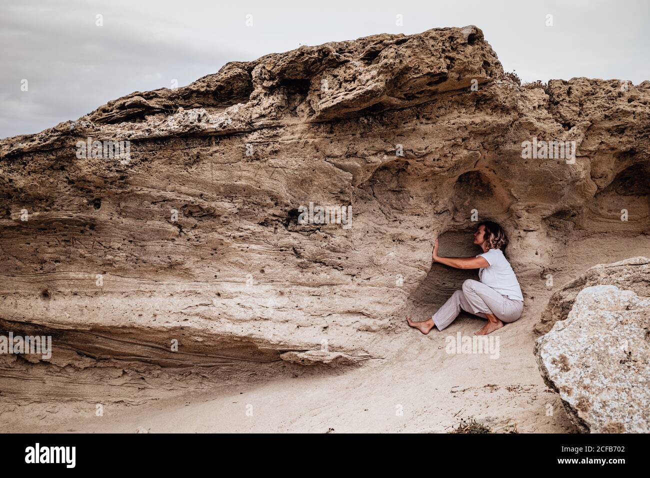 Barefoot Woman meditating in rock cavity Stock Photo - Alamy