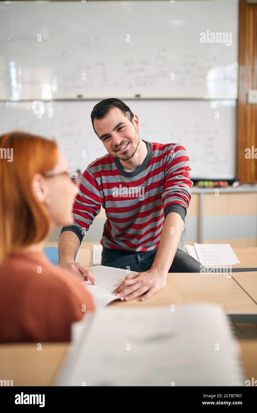 Male student in amphitheater showing lesson to female Stock Photo - Alamy