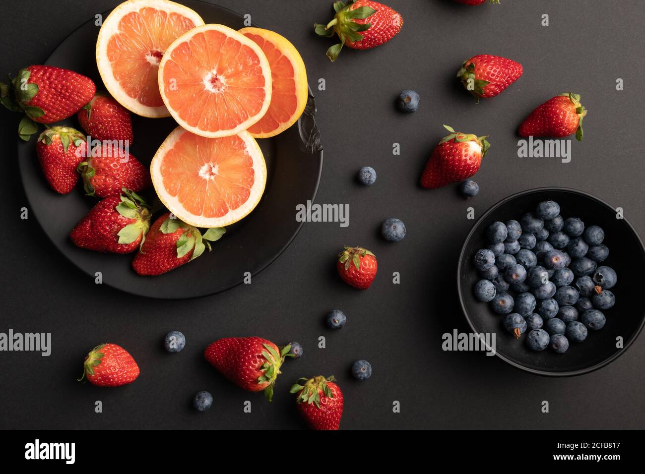 Top view of various fresh fruits for breakfast placed on black ...