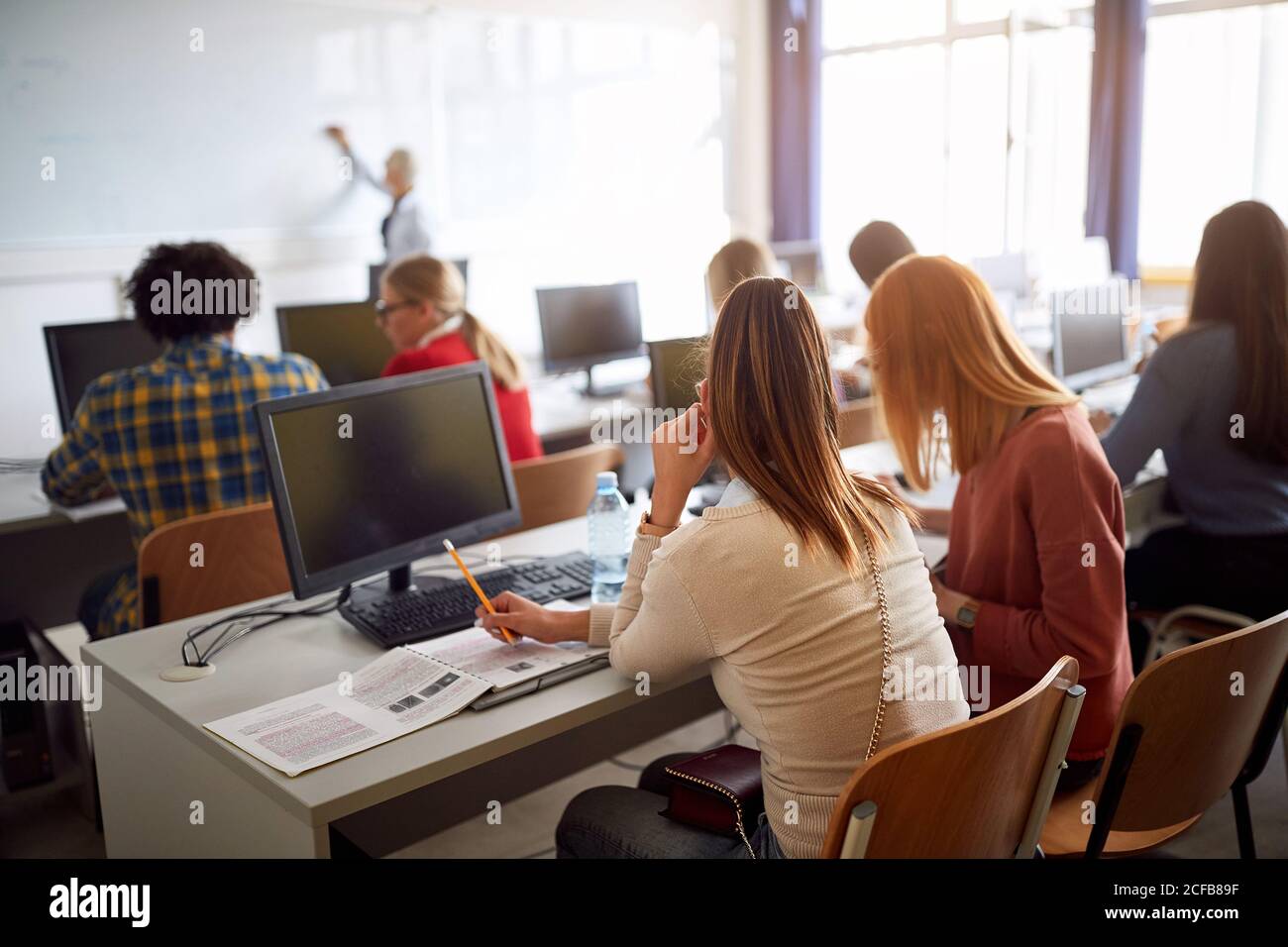 Classroom with pupils and teacher on lecture Stock Photo - Alamy