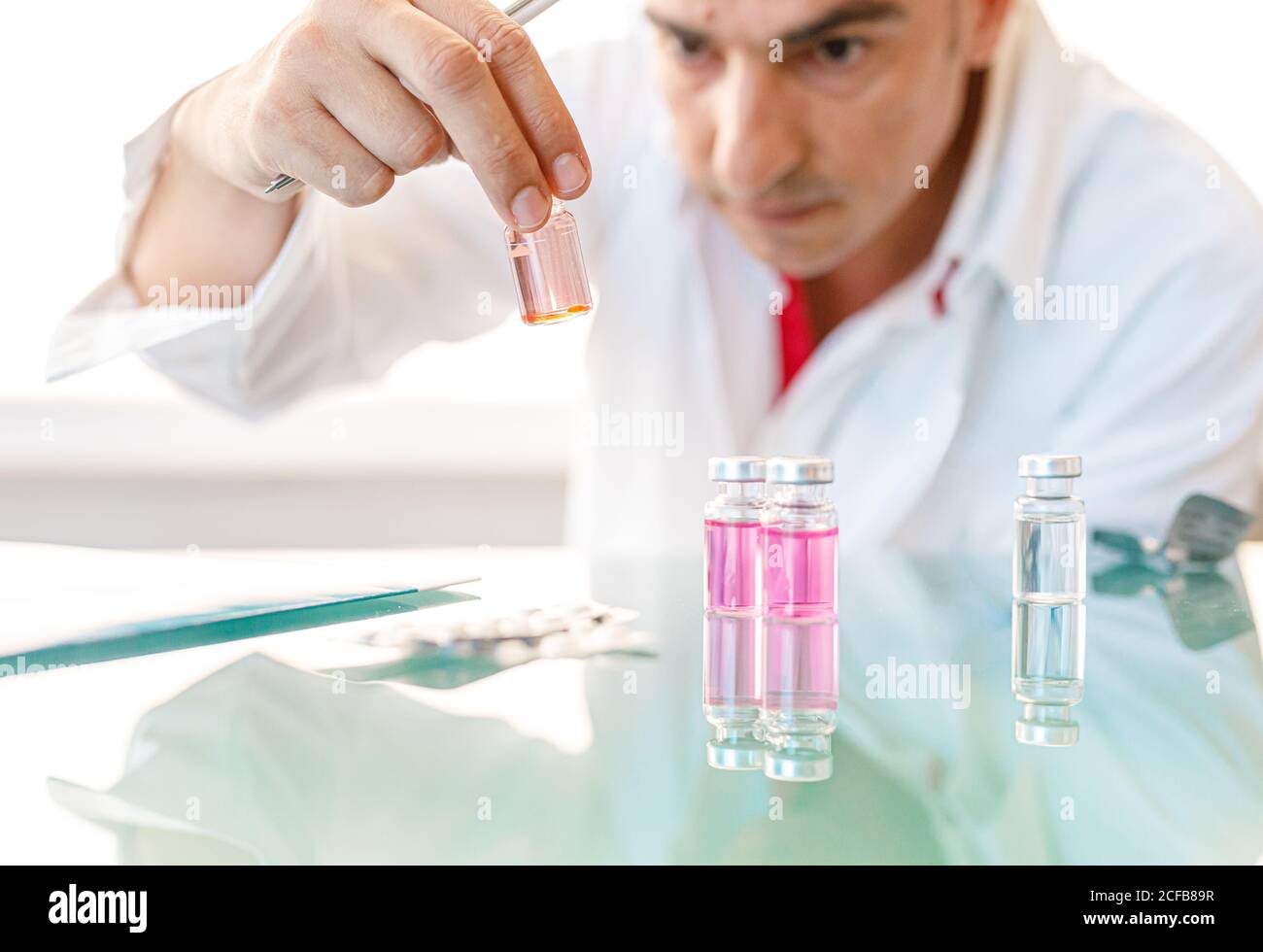 man in white lab coat studying sample Stock Photo - Alamy