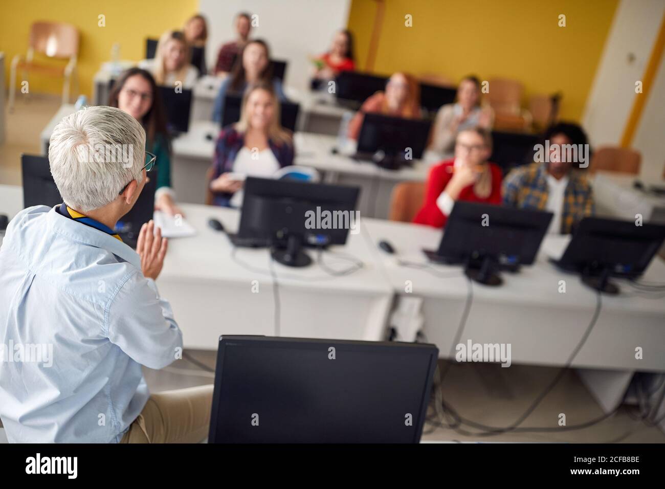 Back view of teacher with pupils in classroom Stock Photo - Alamy