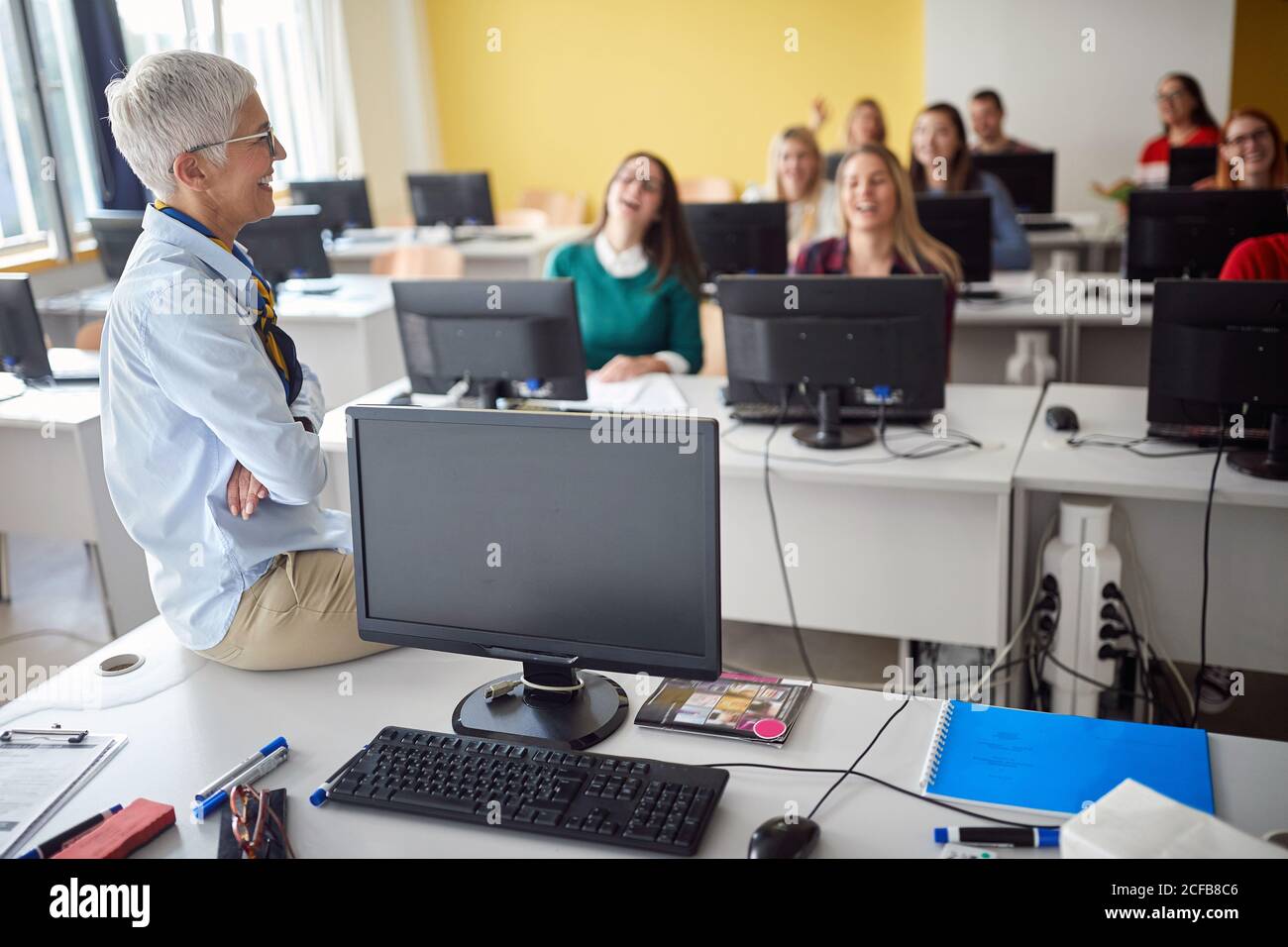Teacher with pupils talking and having fun in classroom Stock Photo - Alamy