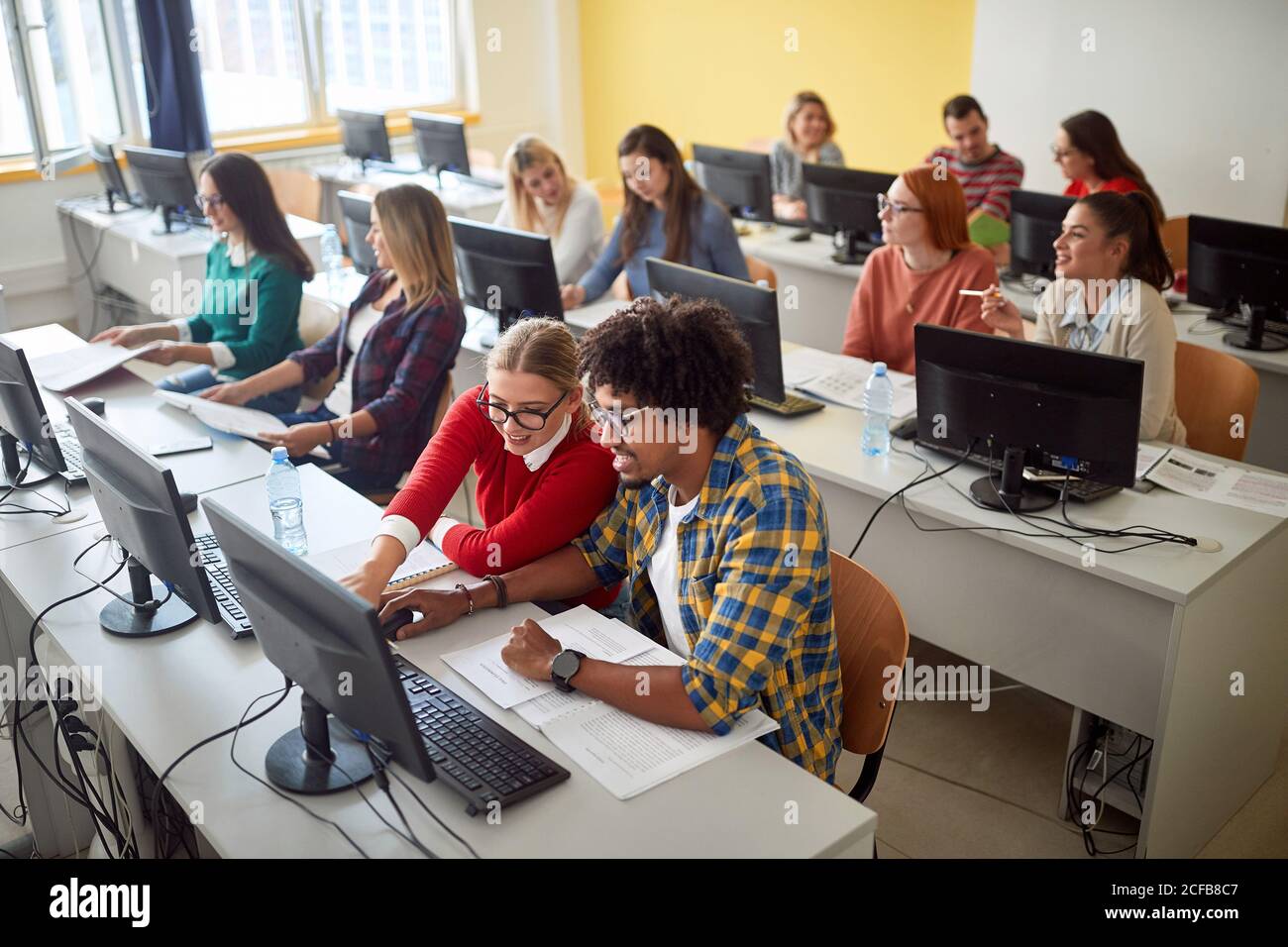 Pupils learning together in classroom Stock Photo - Alamy