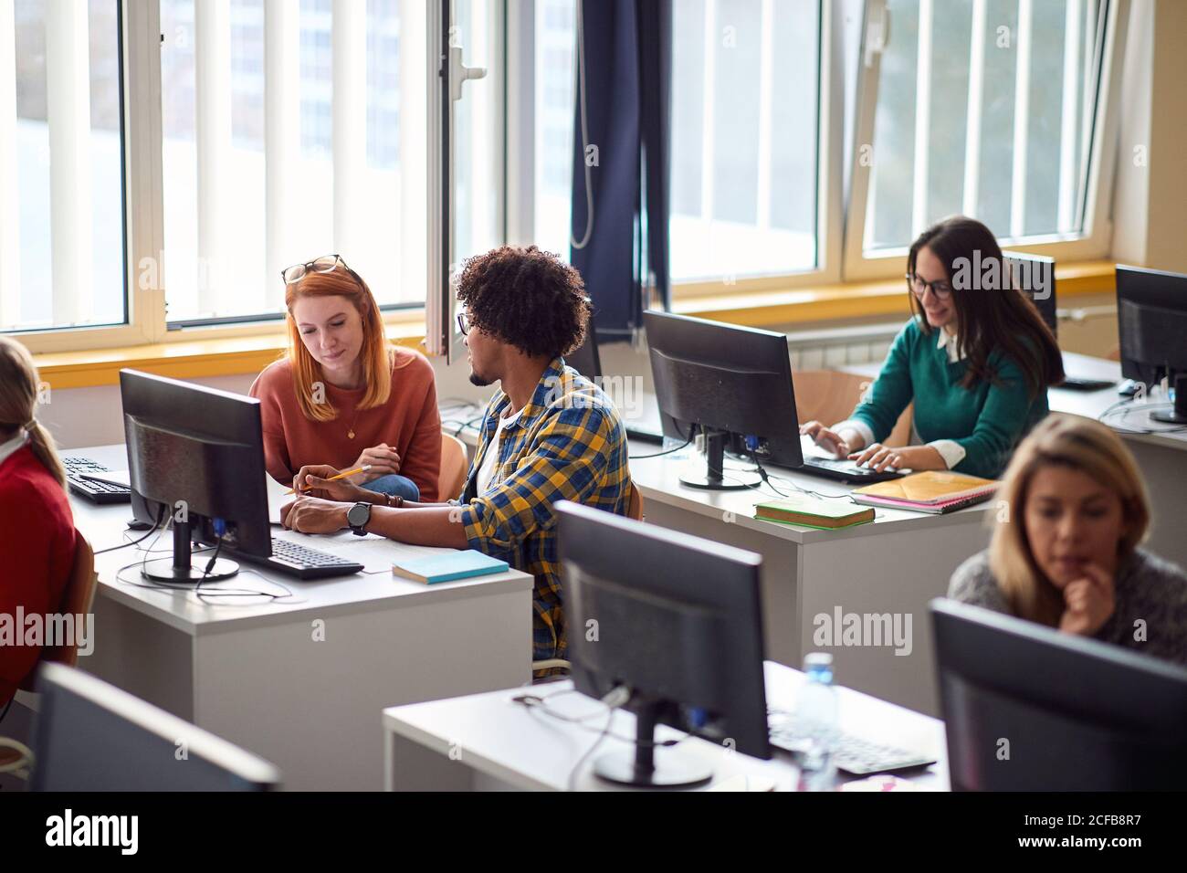 Male and female learning together in classroom Stock Photo - Alamy