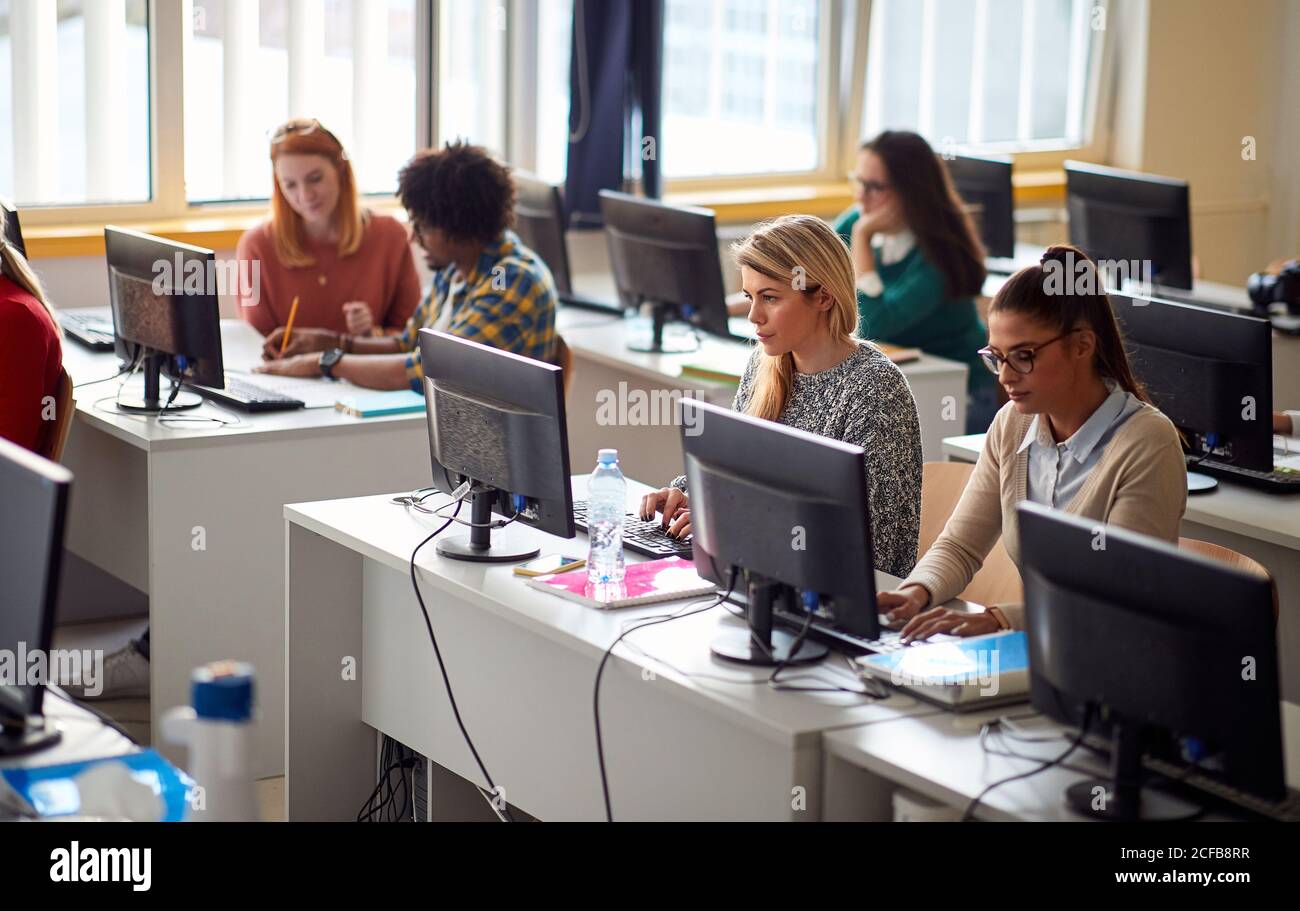 Young people learning together in classroom Stock Photo - Alamy