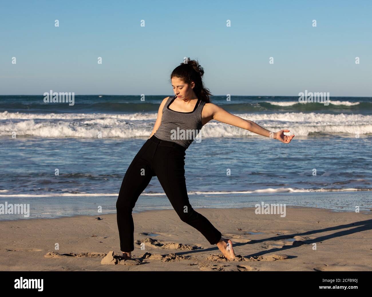 Young dancer on sand coast with waving sea and blue sky Stock Photo - Alamy
