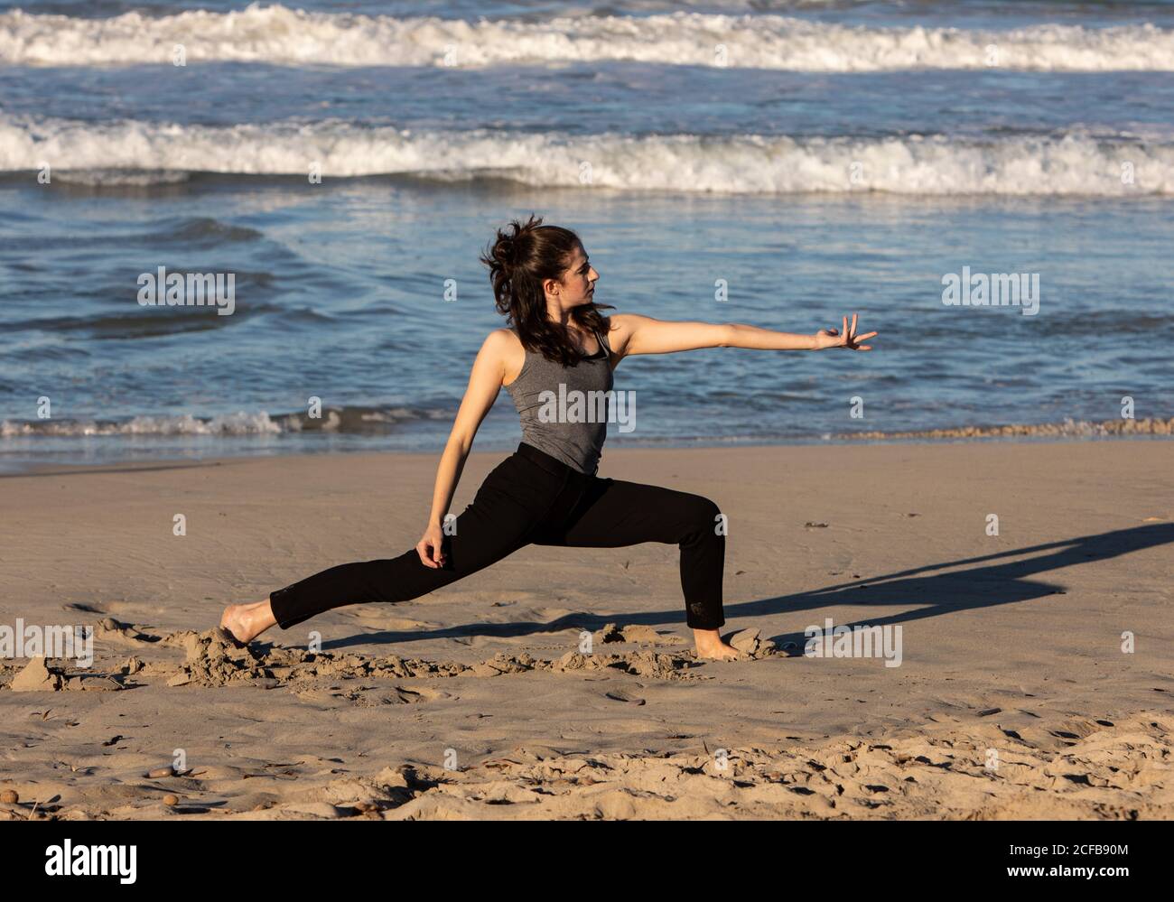 Young dancer posing on sand coast with waving sea and blue sky Stock ...