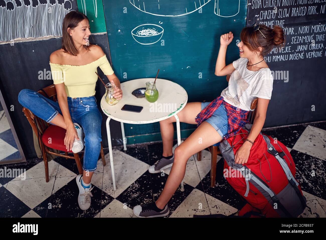 Female friends taking break and having drink in a cafe after long ...