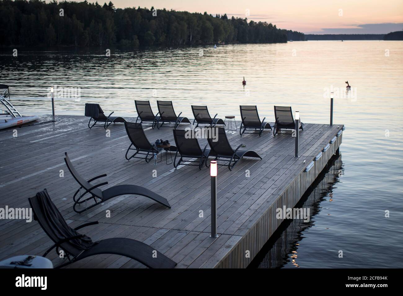 Empty sun loungers on the pier during sunset on the Klyazminskoye ...