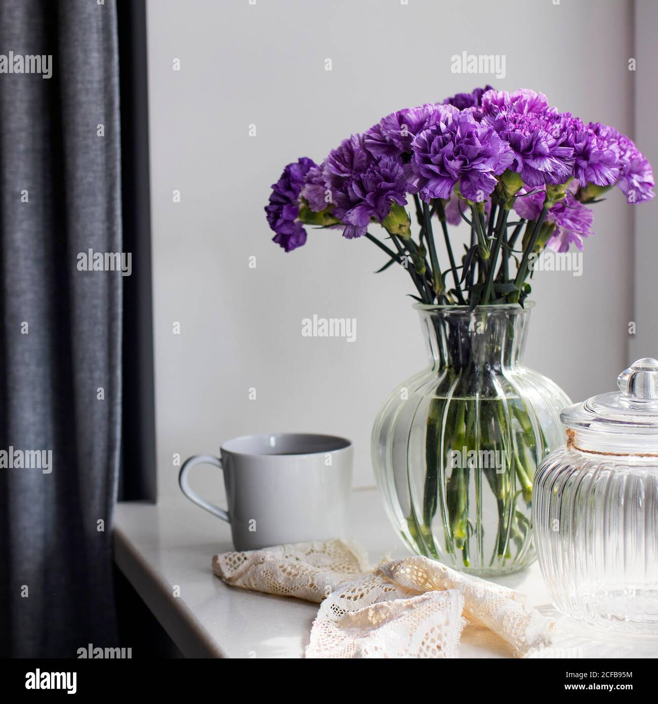 Bridal bouquets of lilac carnations in a four round glass vases ...