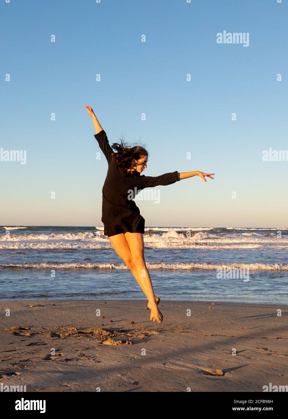 Young dancer posing on sand coast with waving sea and blue sky Stock ...