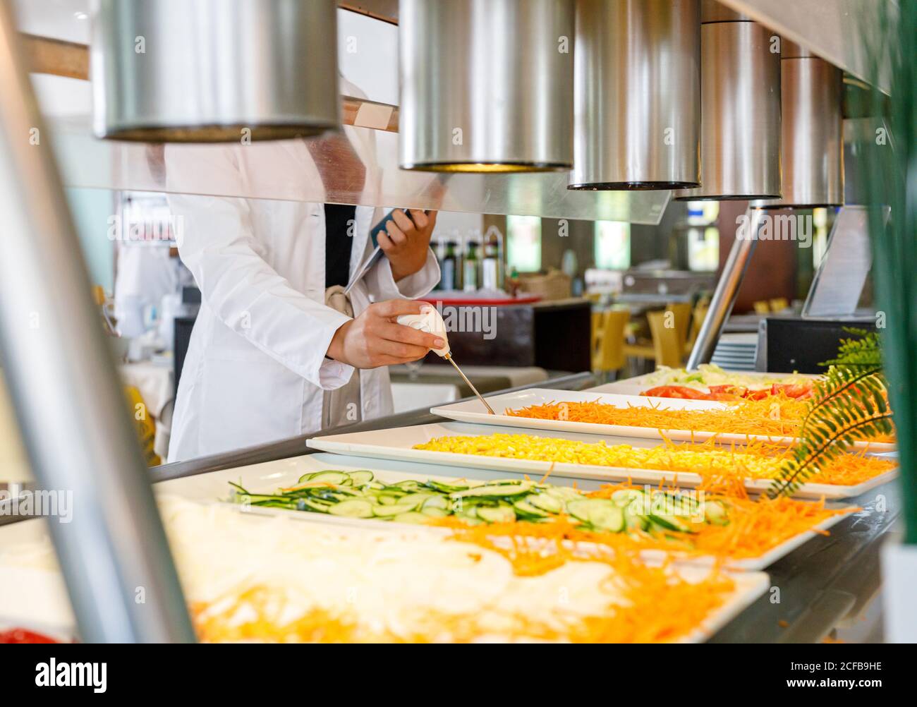 Adult employee checking food quality in canteen Stock Photo - Alamy