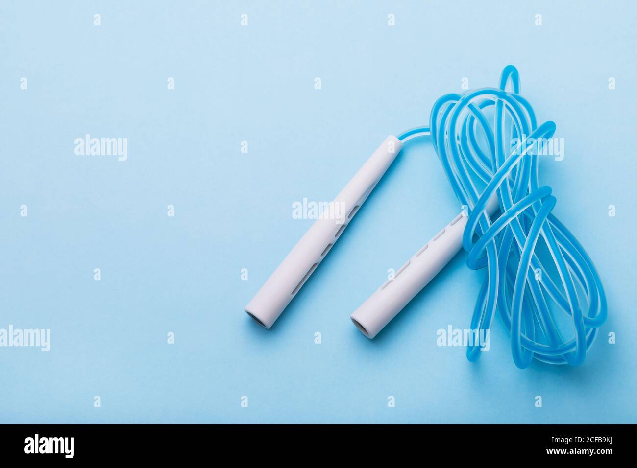 Jump rope on blue background with copy space, top view Stock Photo - Alamy