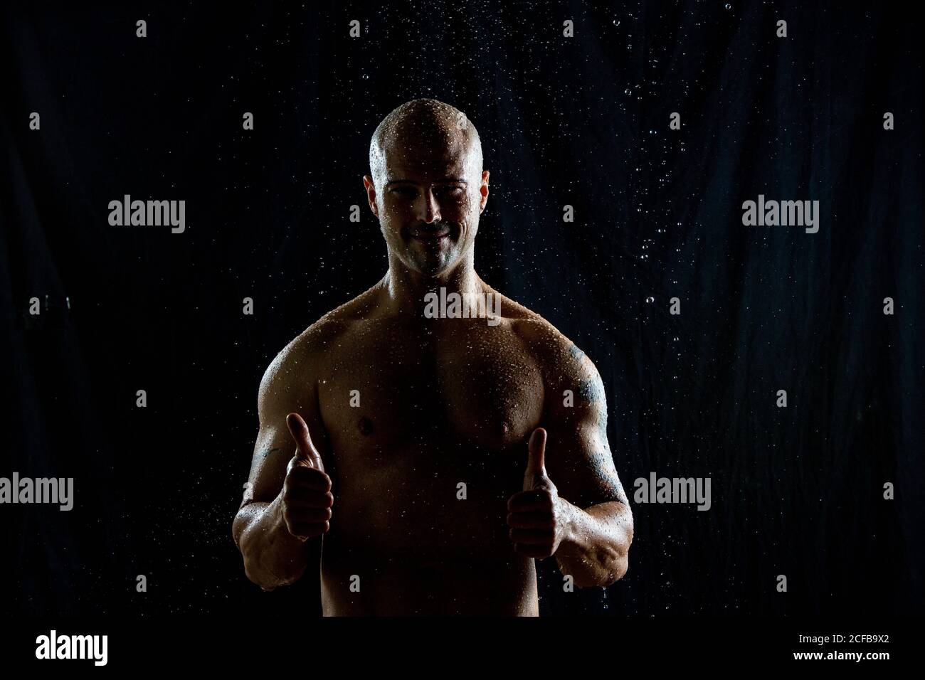 Handsome bald male looking at camera with smiley face expression while ...