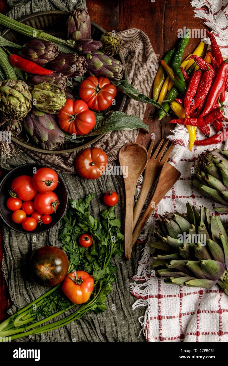 Set of various fresh vegetables and cloth napkins placed on table in ...