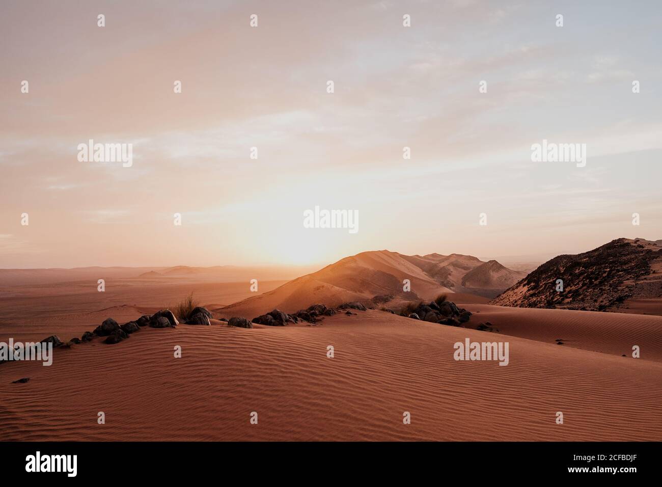 Cloudy sundown sky over hills and rocks in arid desert in evening in ...