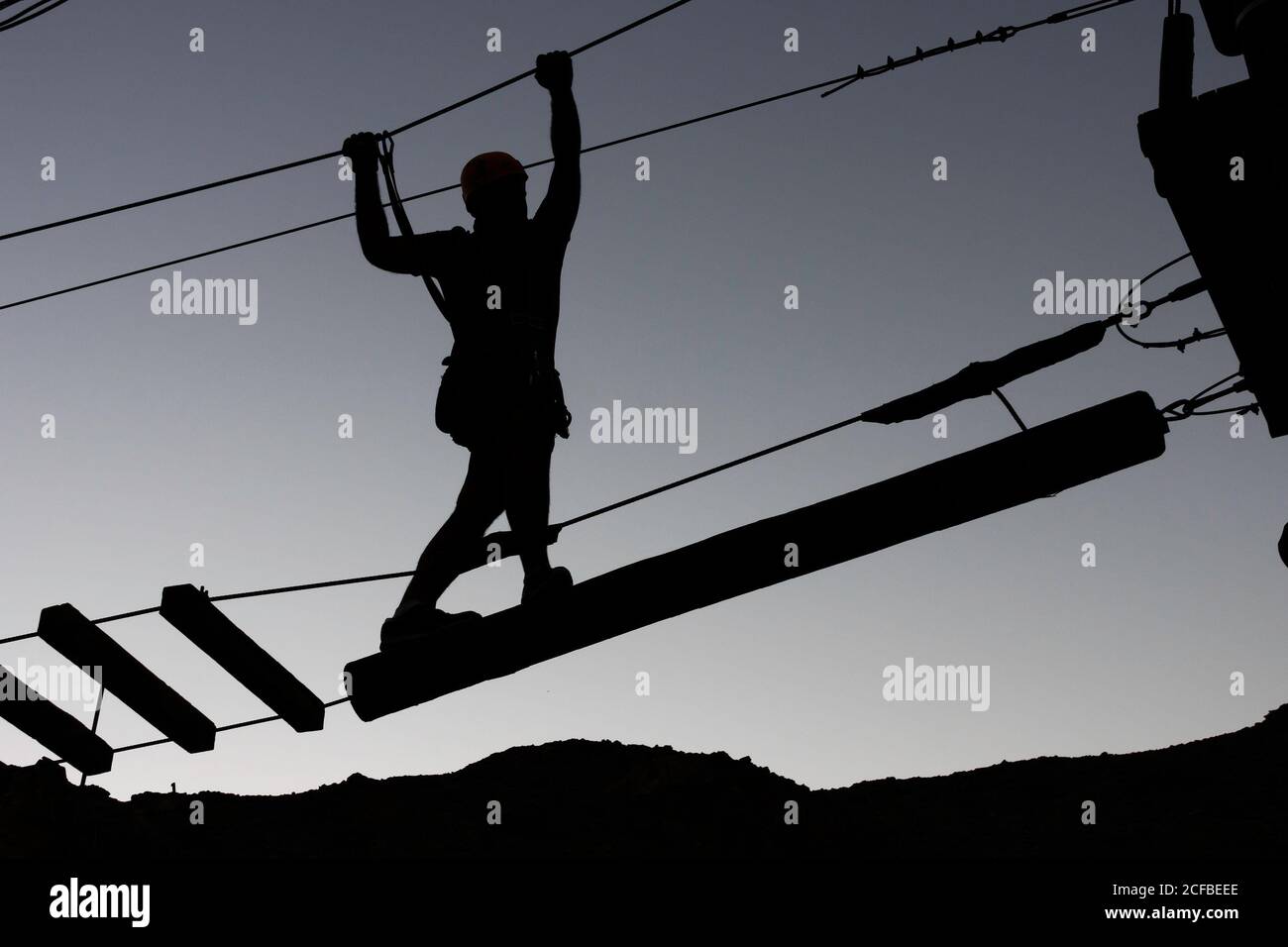 A silhouette of a person on a rope course in an extreme activities ...