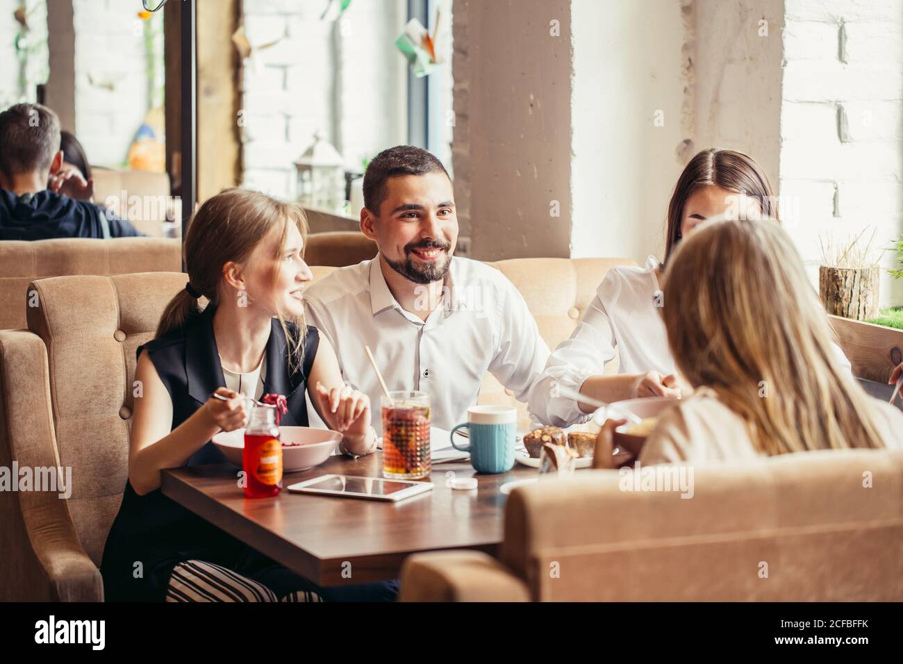Business people are eating, talking and smiling while having lunch in ...