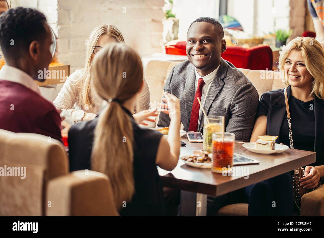 Group Enjoying Business team Lunch In Delicatessen Stock Photo - Alamy