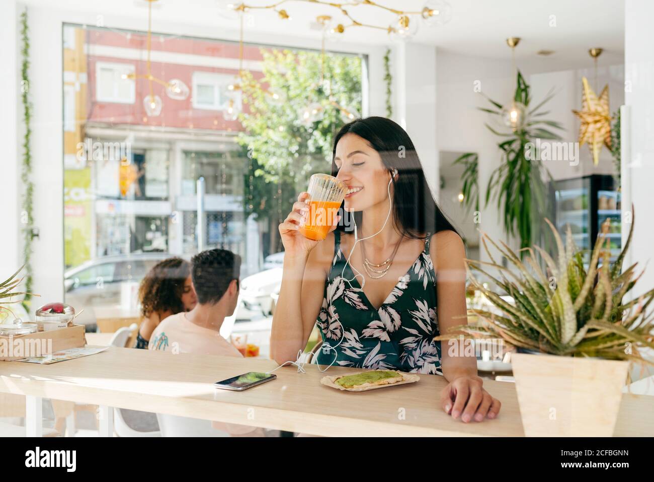 Lady with healthy drink listening to music in cafe Stock Photo - Alamy
