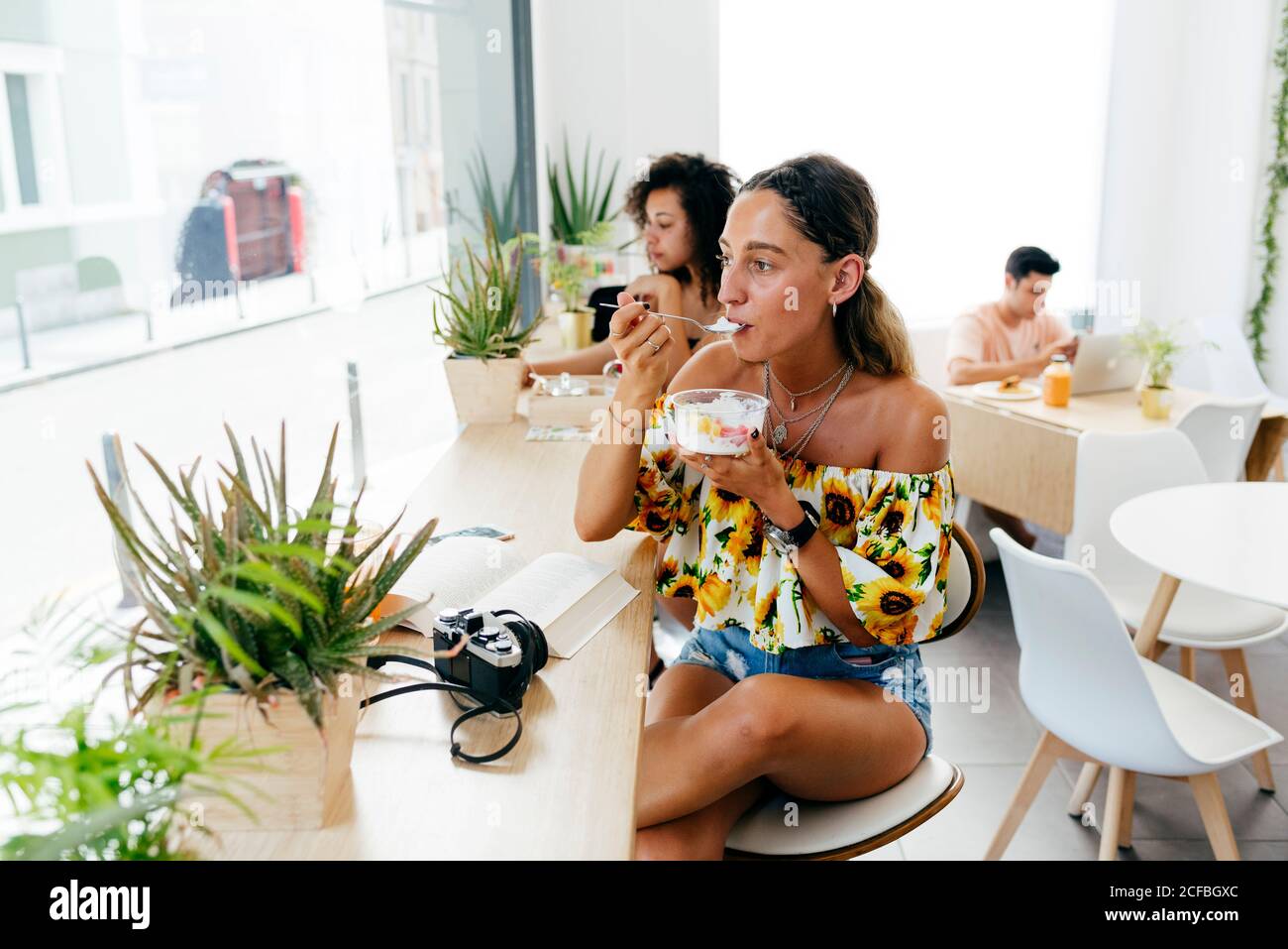 Stylish Woman eating and reading book in cafe Stock Photo - Alamy