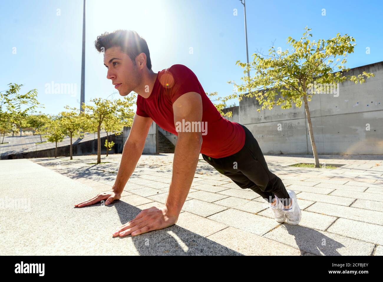 Side view of modern active muscular male wearing red shirt and black ...