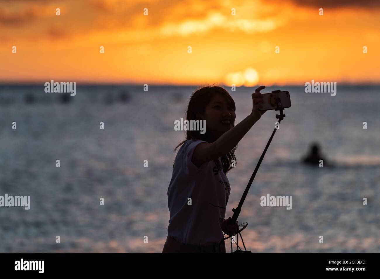 Woman takes selfie in front of ocean at sunset Stock Photo - Alamy