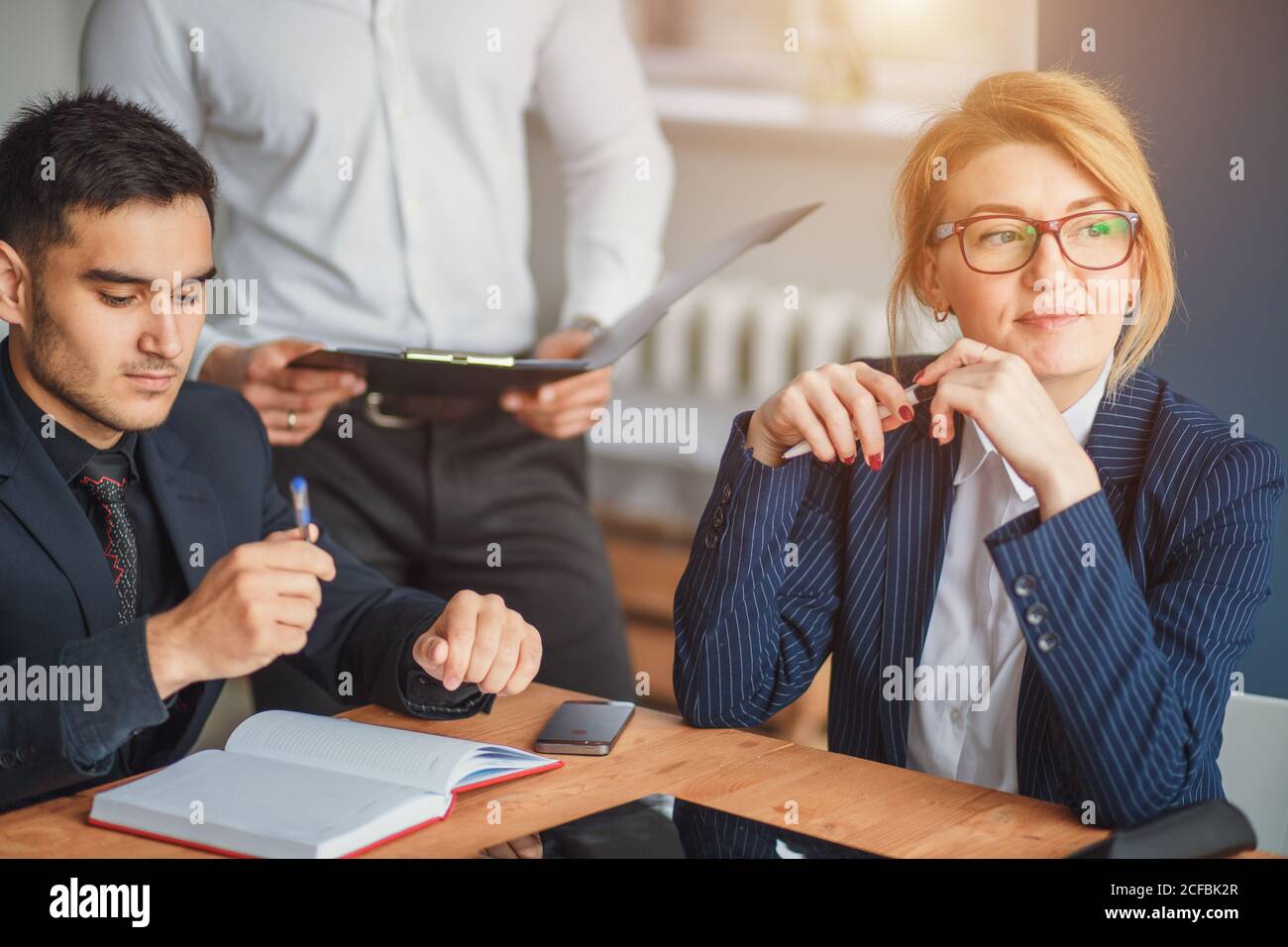 Beautiful female boss and coworkers sitting in her office Stock Photo ...