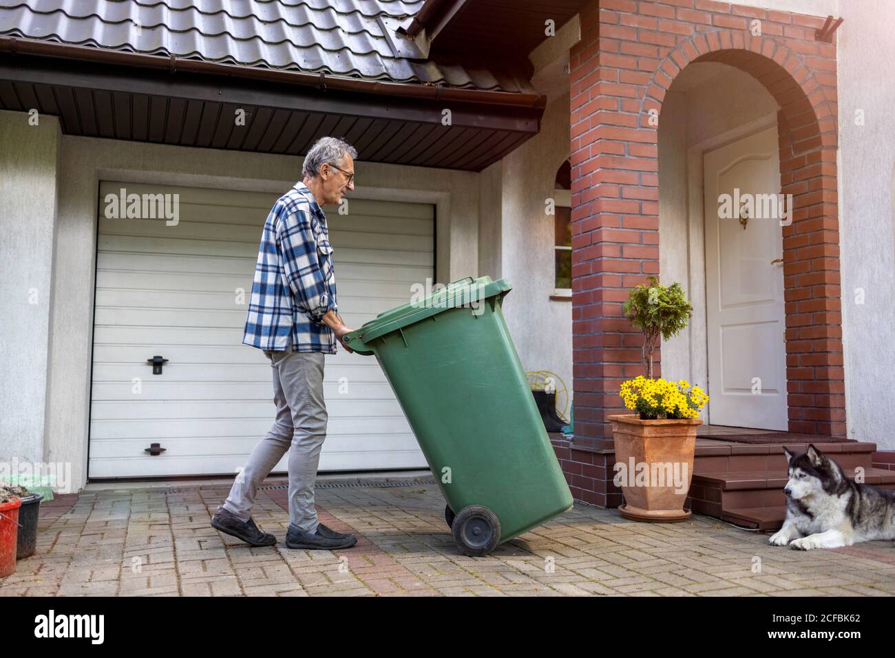 Senior man taking out garbage Stock Photo - Alamy