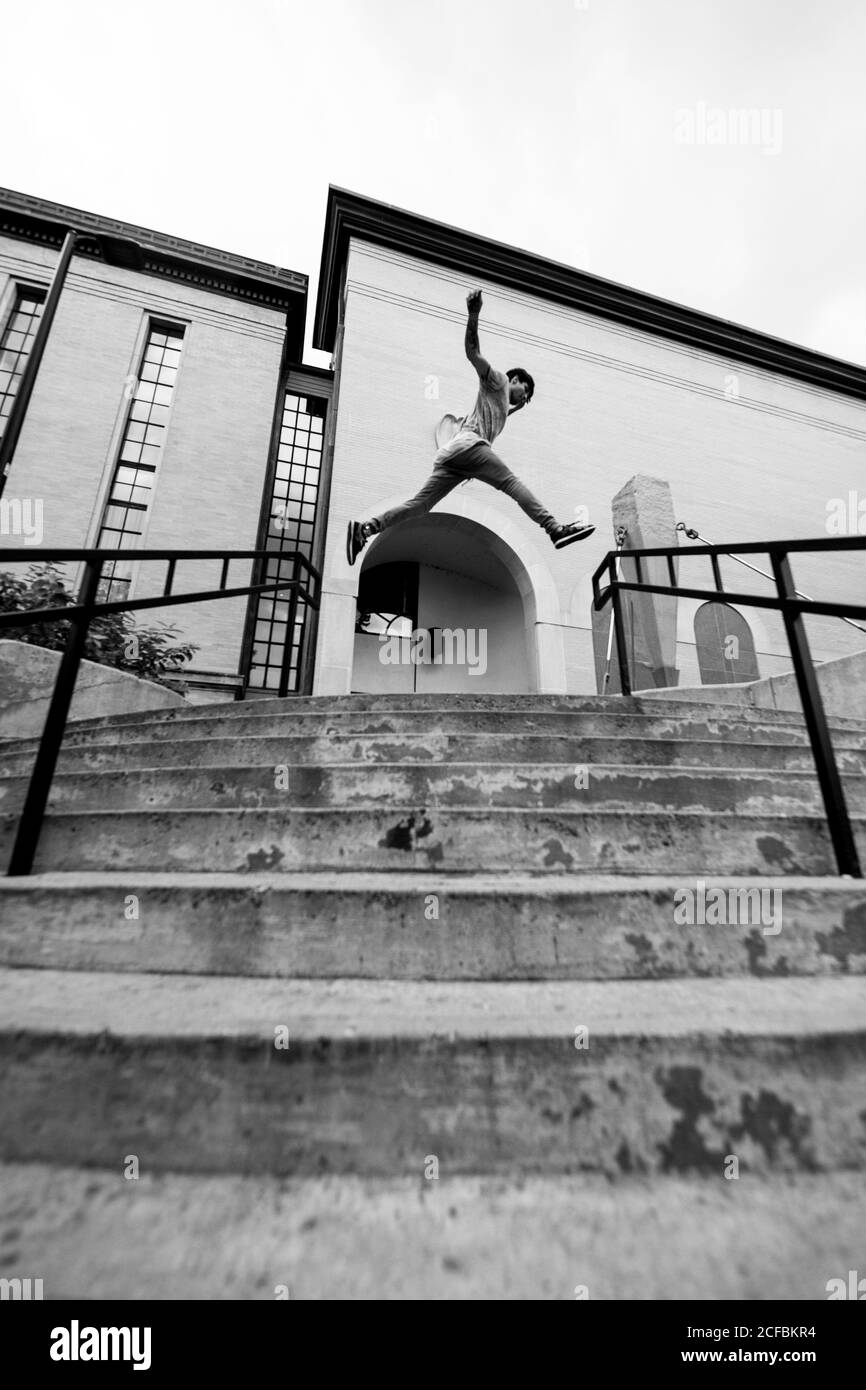 Black and White parkour male athlete jumping between railings Stock ...