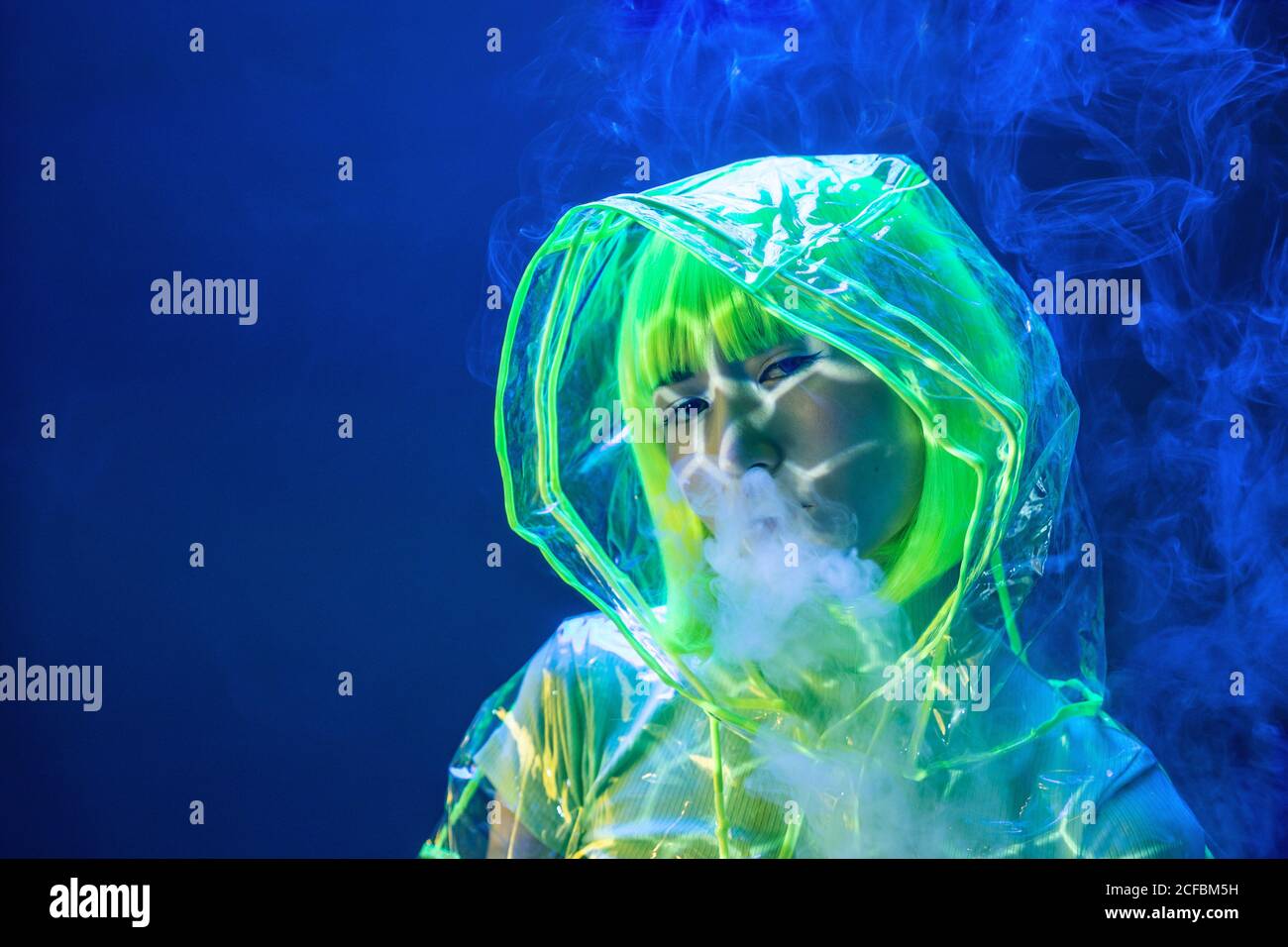 Young pretty unusual Asian Woman in plastic transparent raincoat and ...