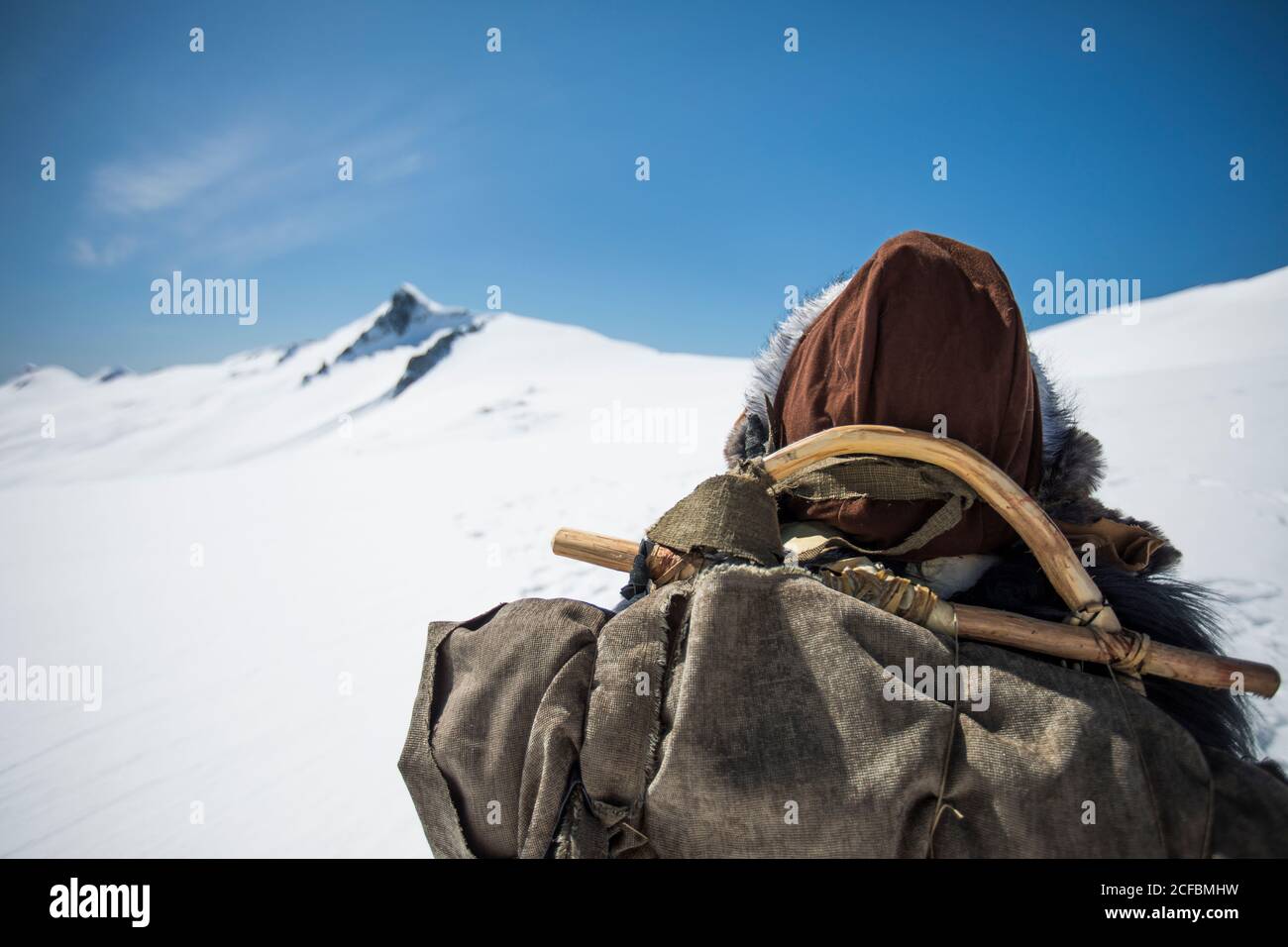 Rear view of First Nations explorer, wood backpack and fur clothing ...