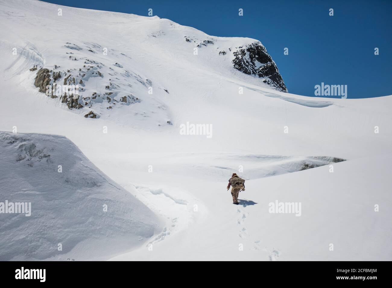 First Nations Hunter exploring high altitude landscape in mountains ...