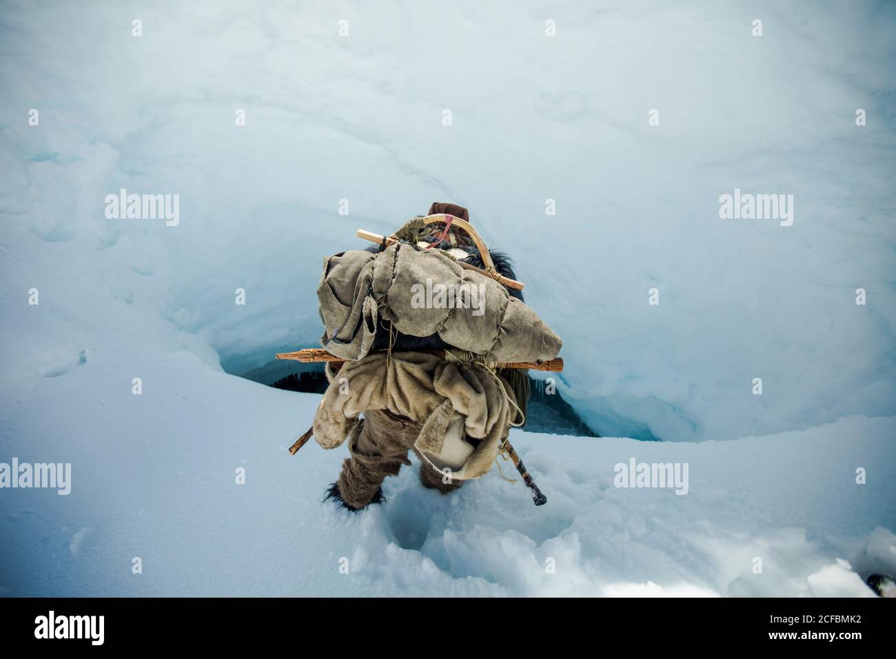 Mountaineer approaches a steep hole, access to ice cave Stock Photo - Alamy