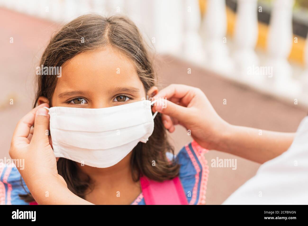 Mother puts on her child sterile medical mask. Child, wearing face mask ...