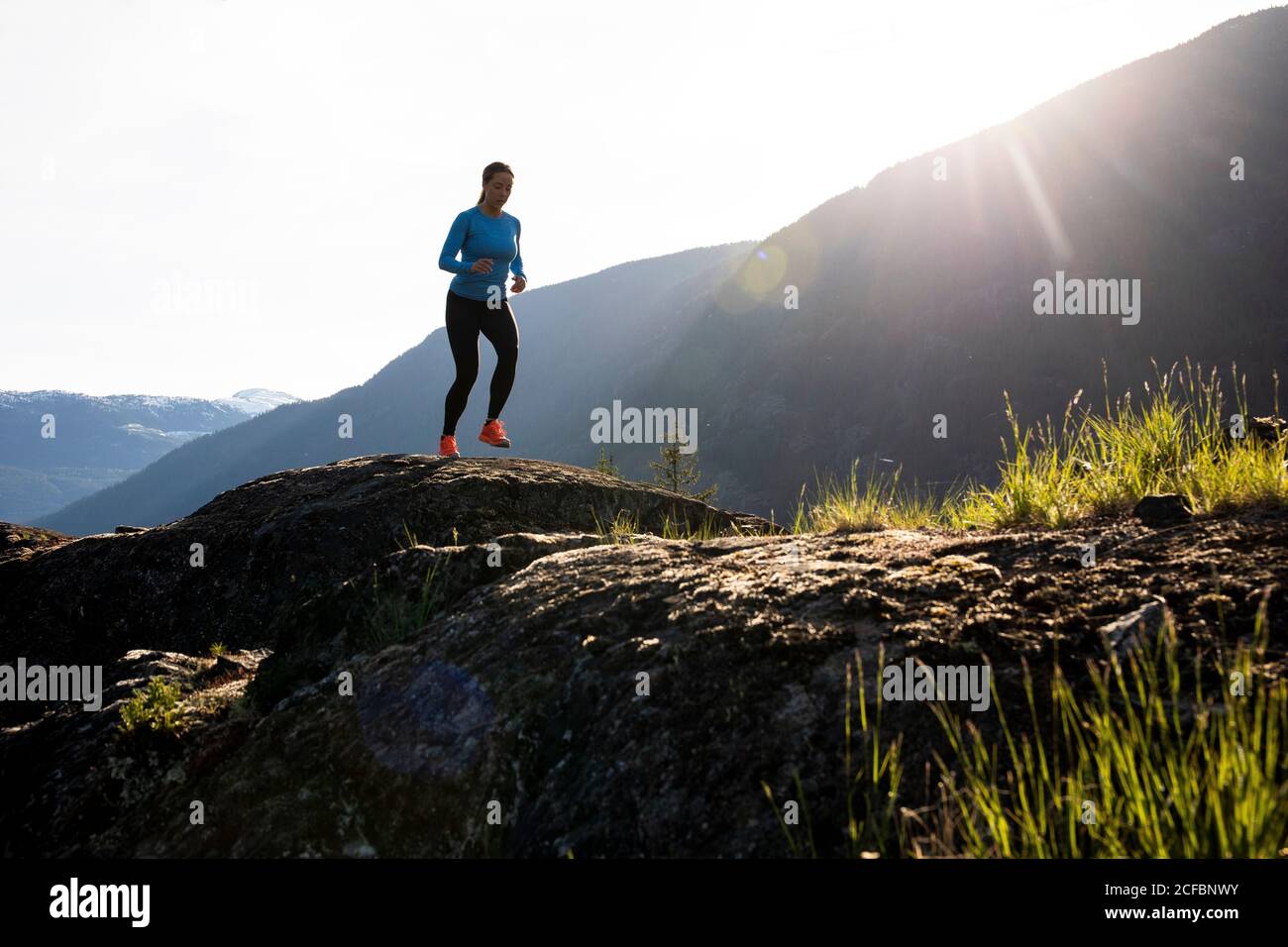 Sportswoman running on stones in highlands Stock Photo - Alamy