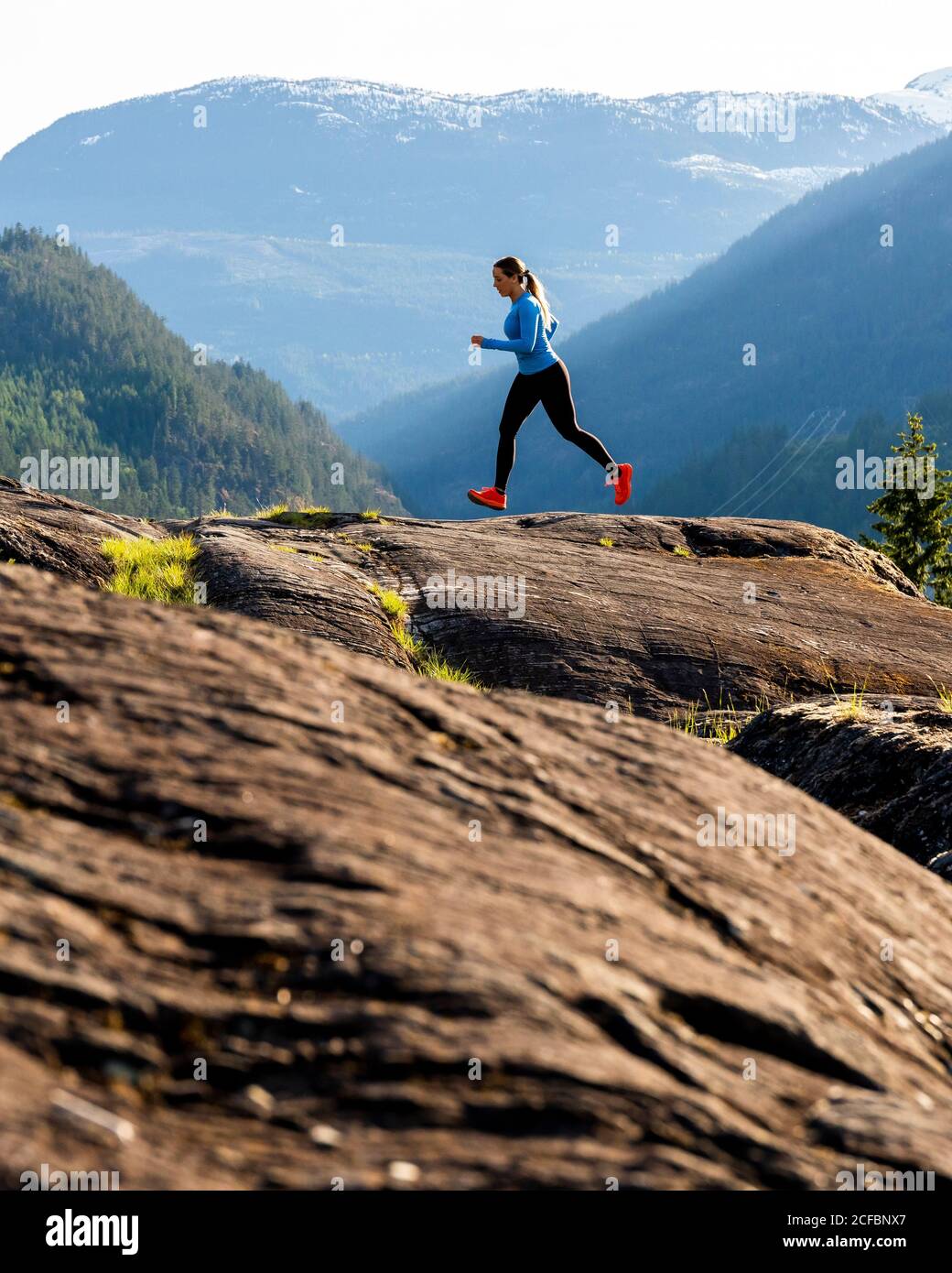 Sportswoman running on stones in highlands Stock Photo - Alamy