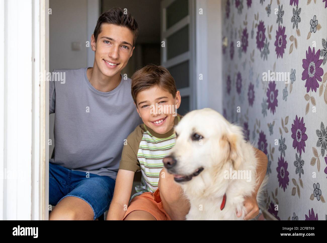 Two brothers standing in doorway of their house Stock Photo - Alamy