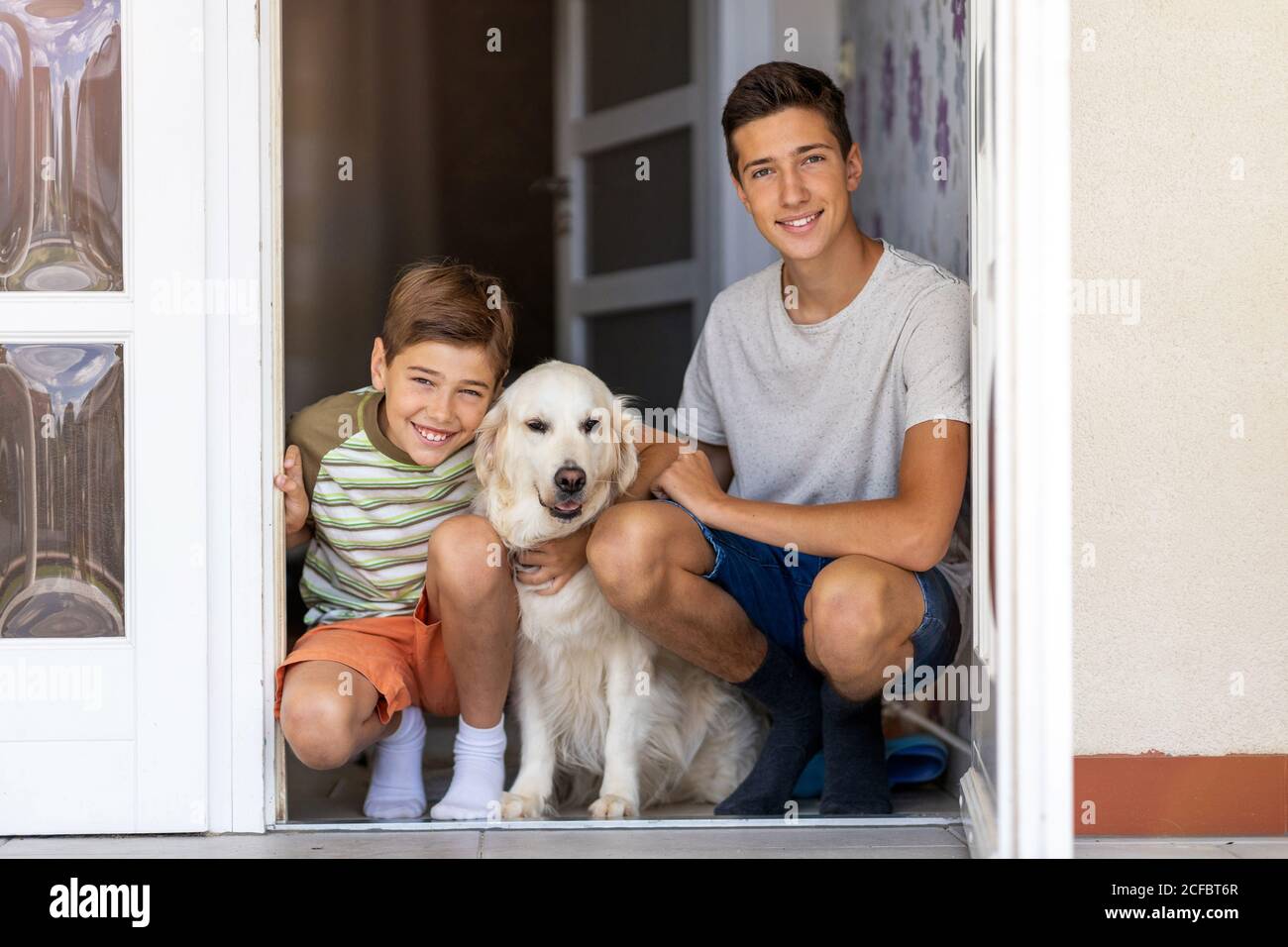 Two brothers standing in doorway of their house Stock Photo - Alamy