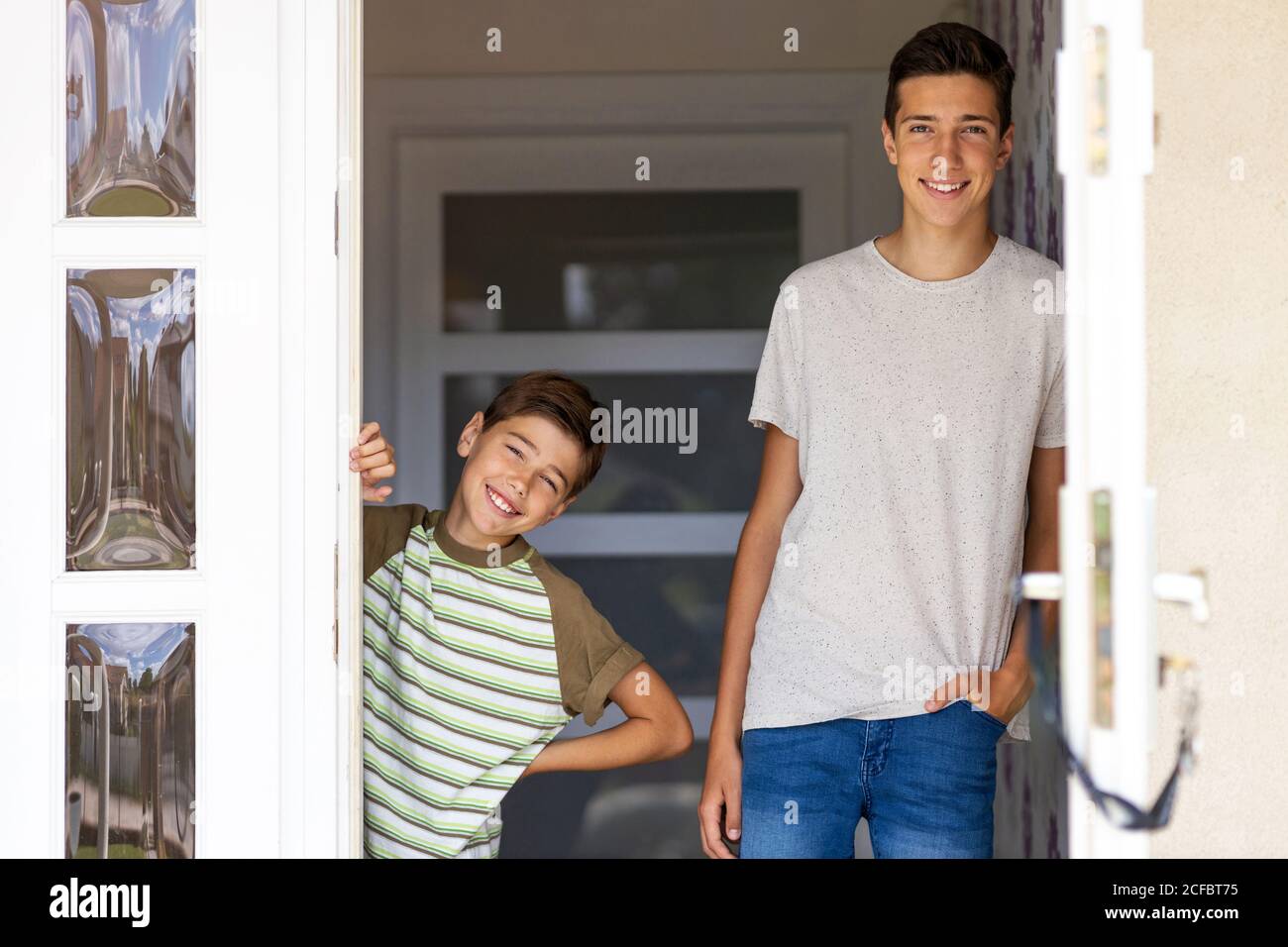 Two brothers standing in doorway of their house Stock Photo - Alamy