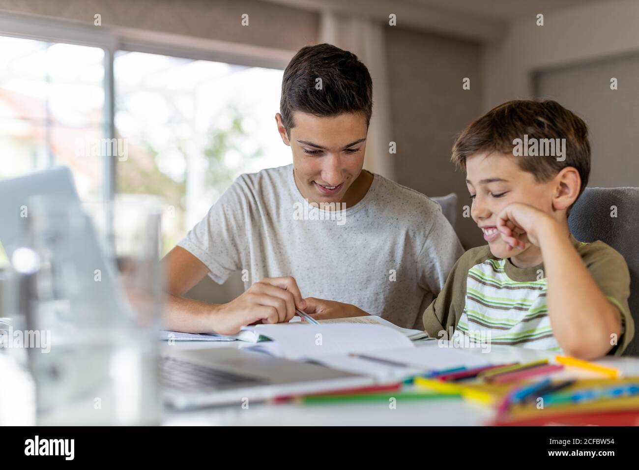 Teenage boy helping his younger brother doing homework at home Stock ...