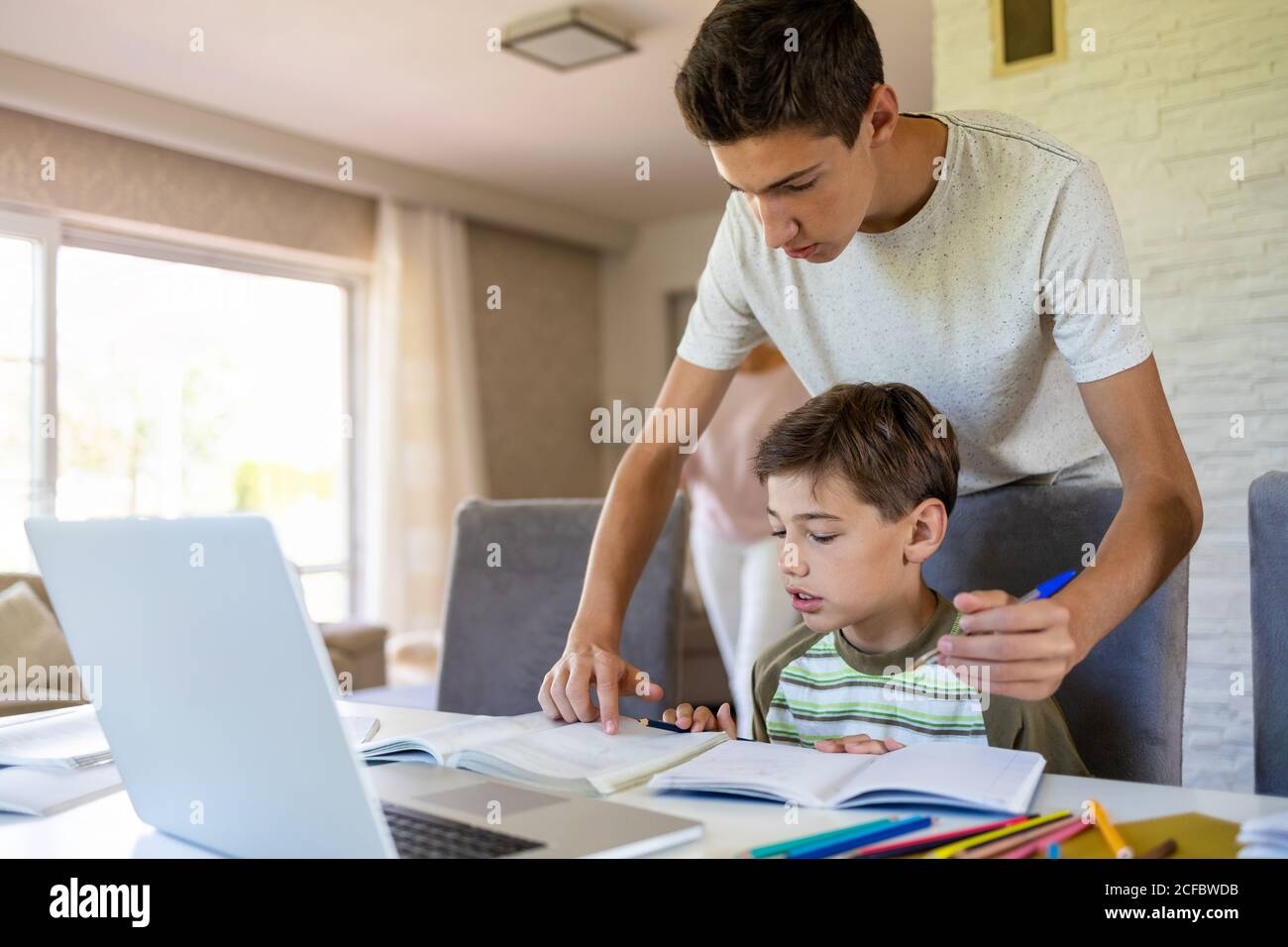Teenage boy helping his younger brother doing homework at home Stock ...
