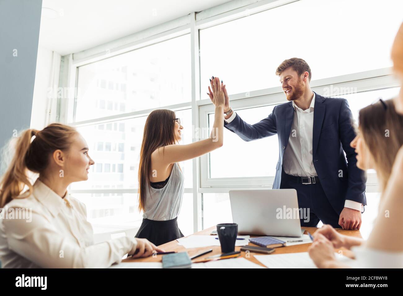 Happy successful business team giving a high fives gesture as they ...