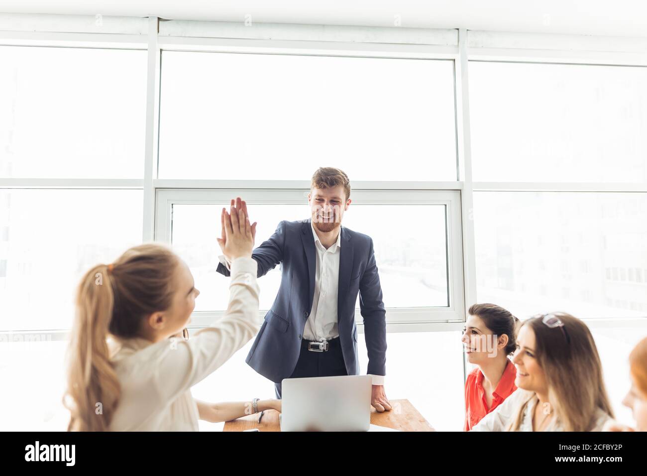 Happy successful business team giving a high fives gesture as they ...